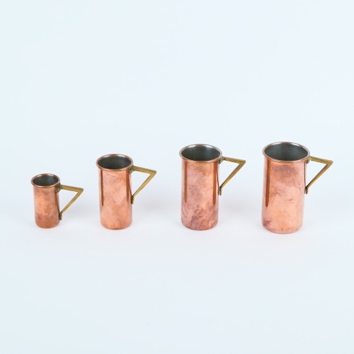 A Set of Four Arts And Crafts Measuring Cups