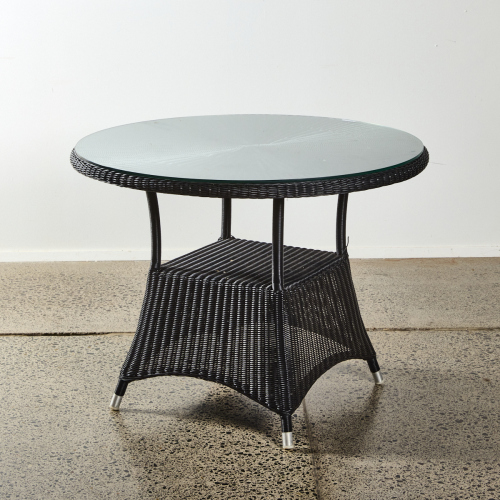 A Circular Outdoor Table With A Glass Overlay